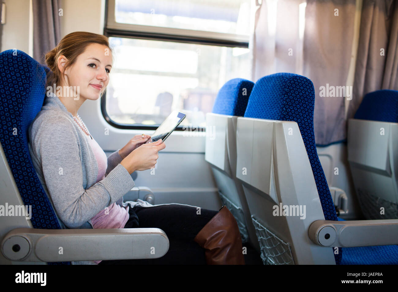 Young woman using her tablet computer while traveling by train Stock ...