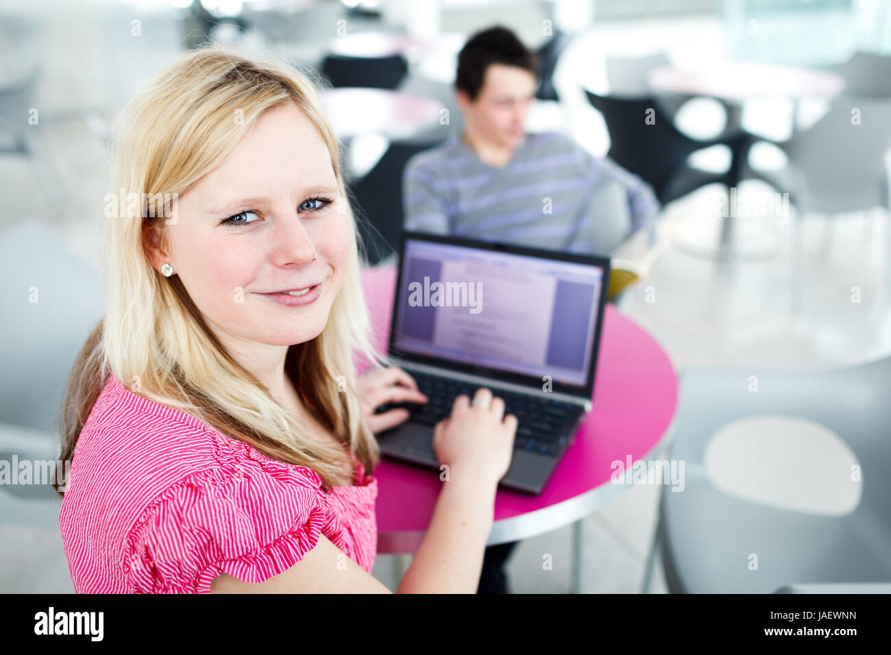 Two college students having fun studying together, using a laptop ...