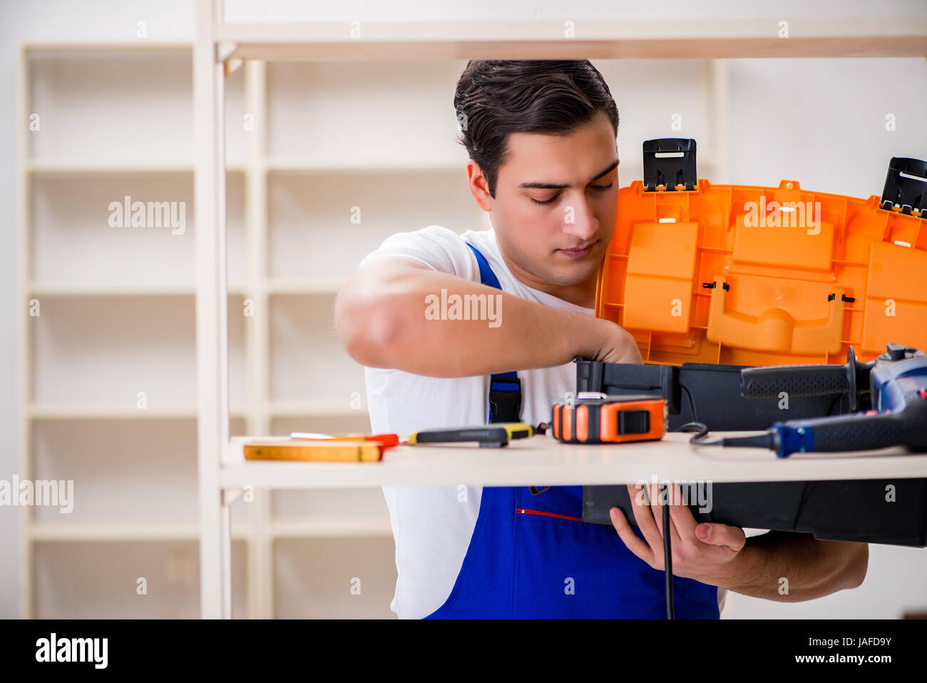 Worker man repairing assembling bookshelf Stock Photo - Alamy