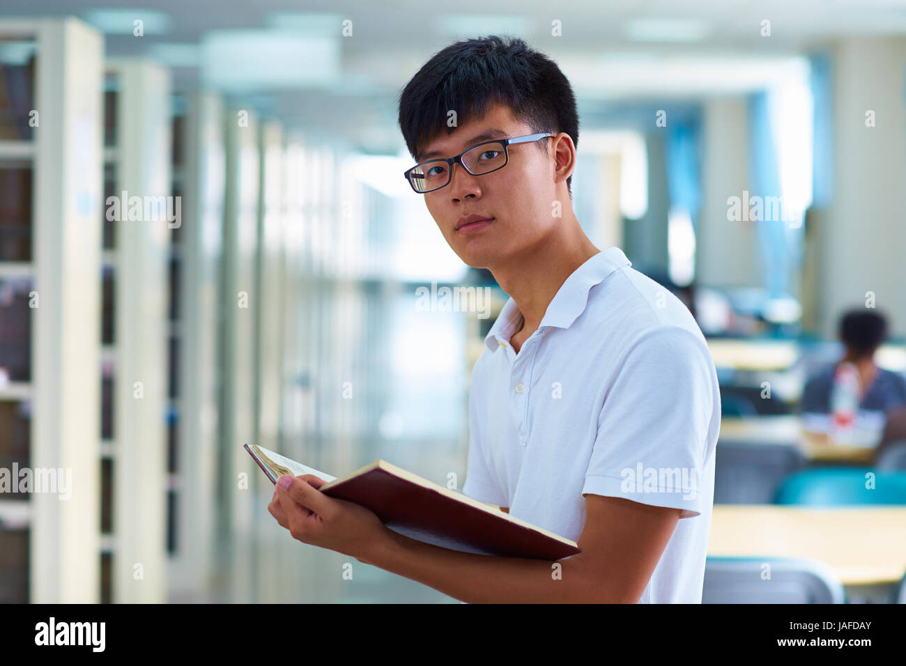 One young male asian or Chinese college students looking at camera ...