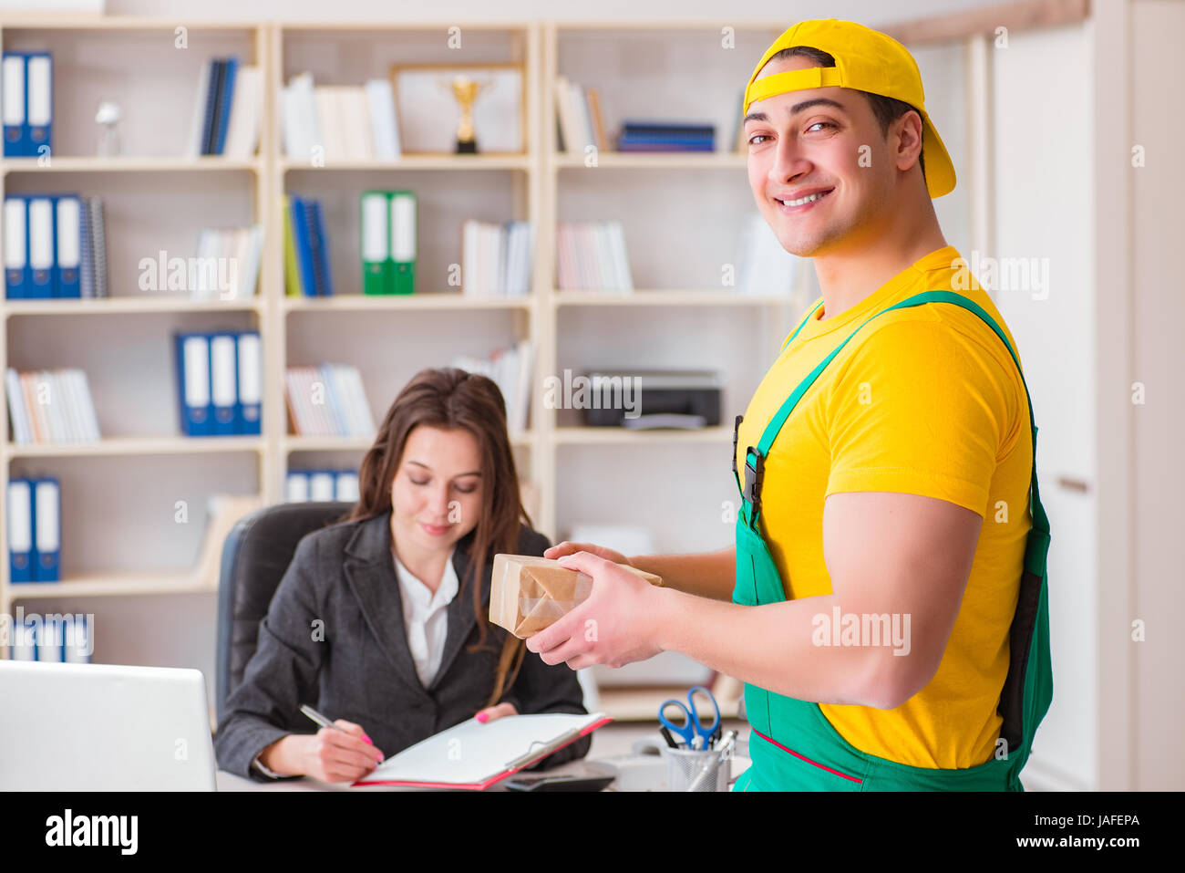Postman delivering parcel to the office Stock Photo - Alamy