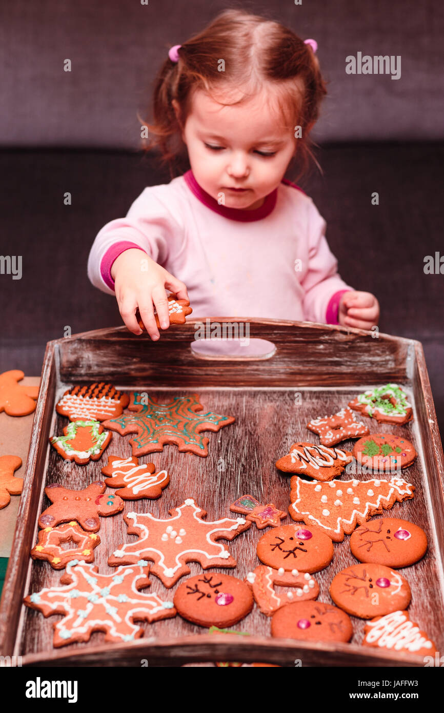 Little girl placing Christmas gingerbread cookies on wooden tray Stock ...