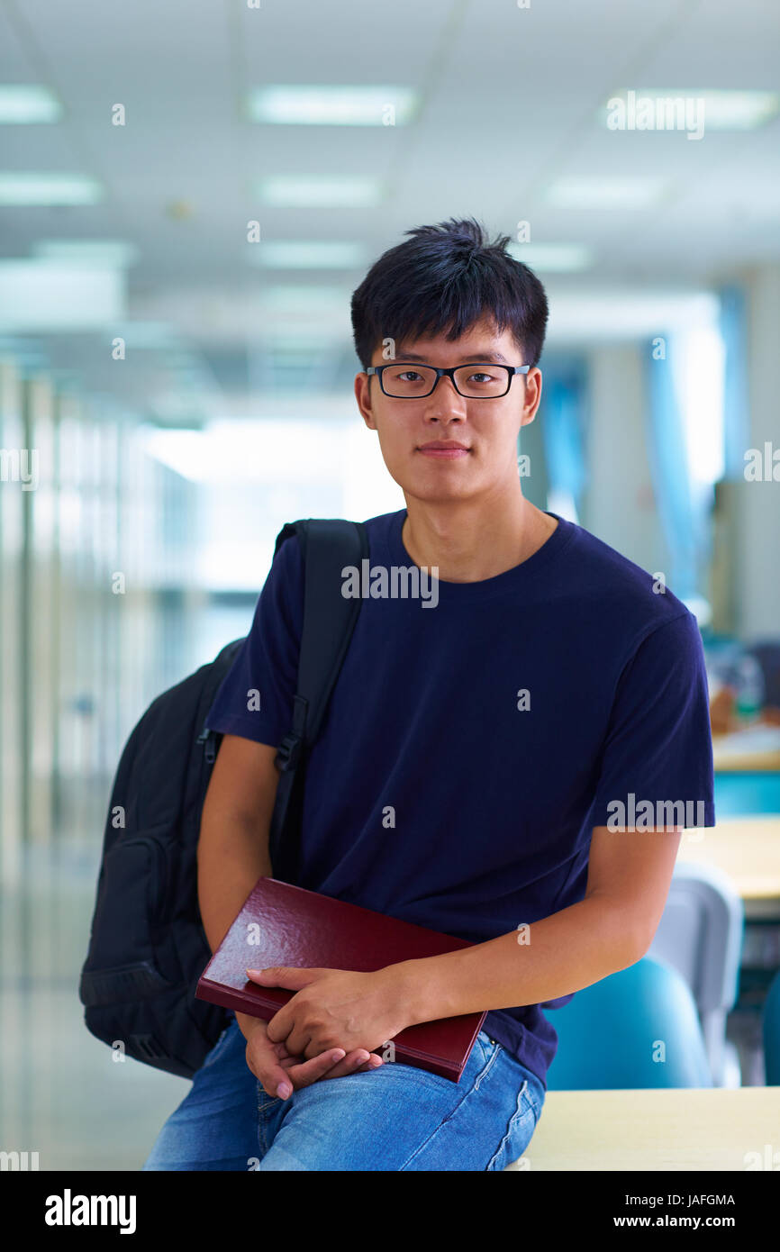 One young male asian or Chinese college students looking at camera ...