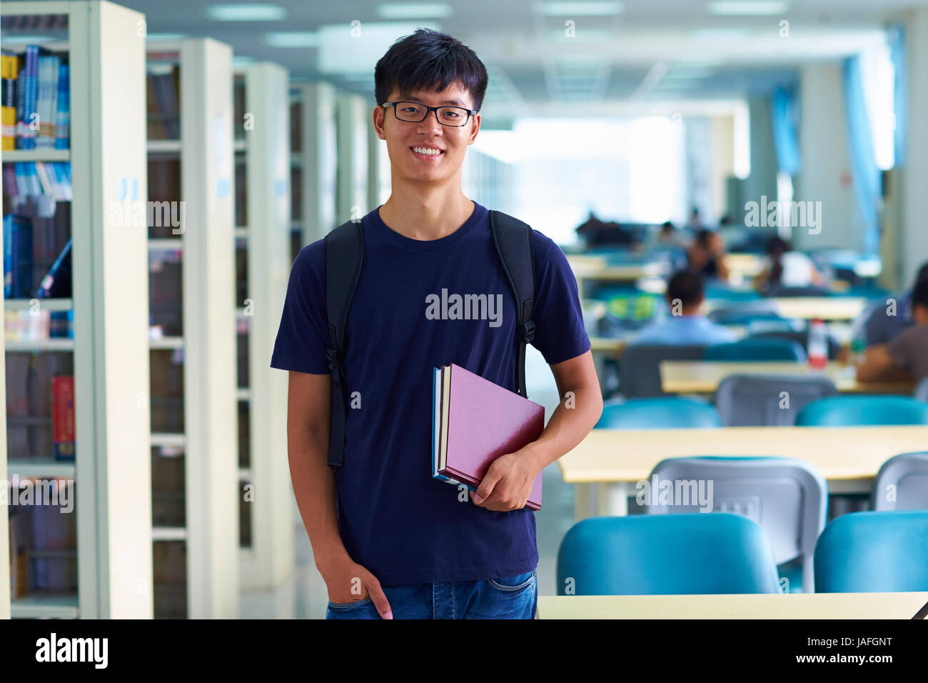 Man standing in front bookshelf hi-res stock photography and images - Alamy
