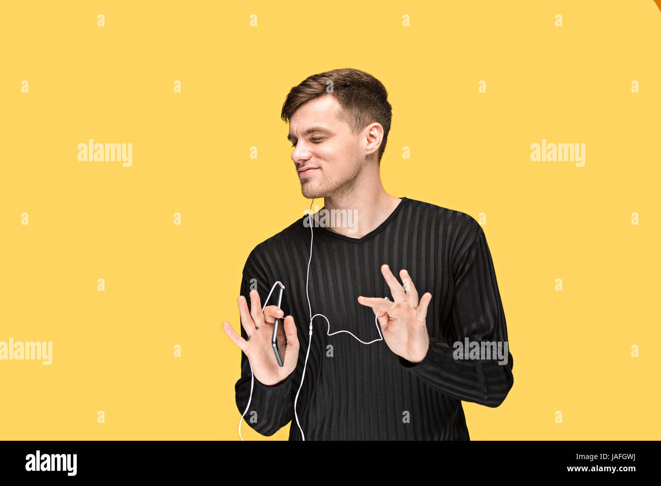 The handsome young man standing and listening music Stock Photo - Alamy