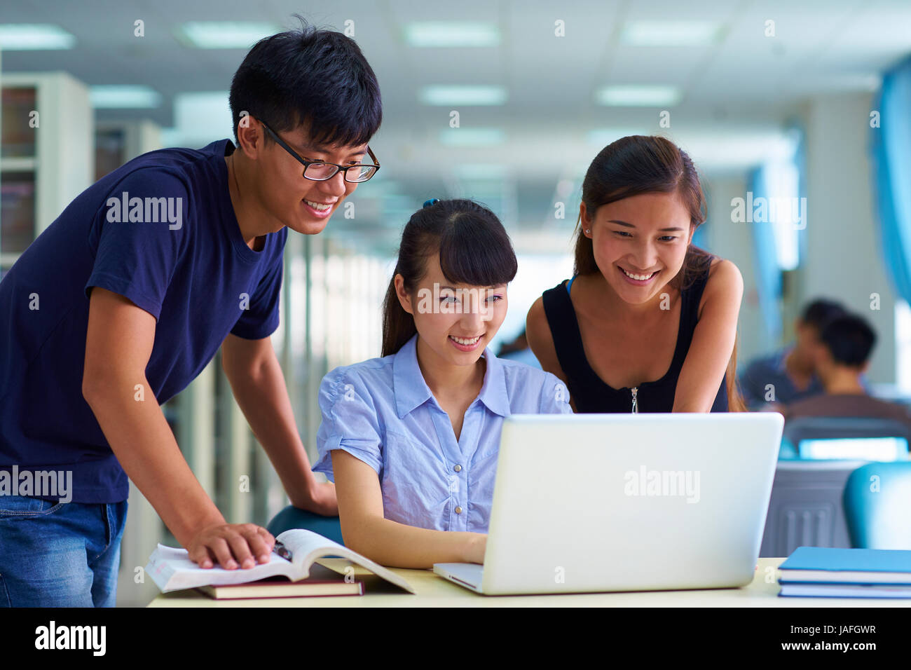 Happy young Chinese or Asian college students study together in the ...