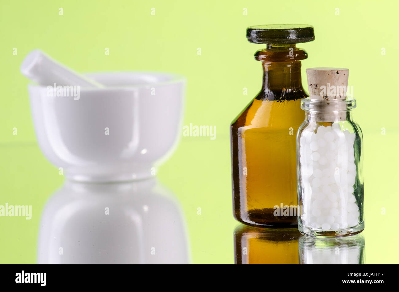 homeopathic pills with glassbottle and mortar, green background Stock ...