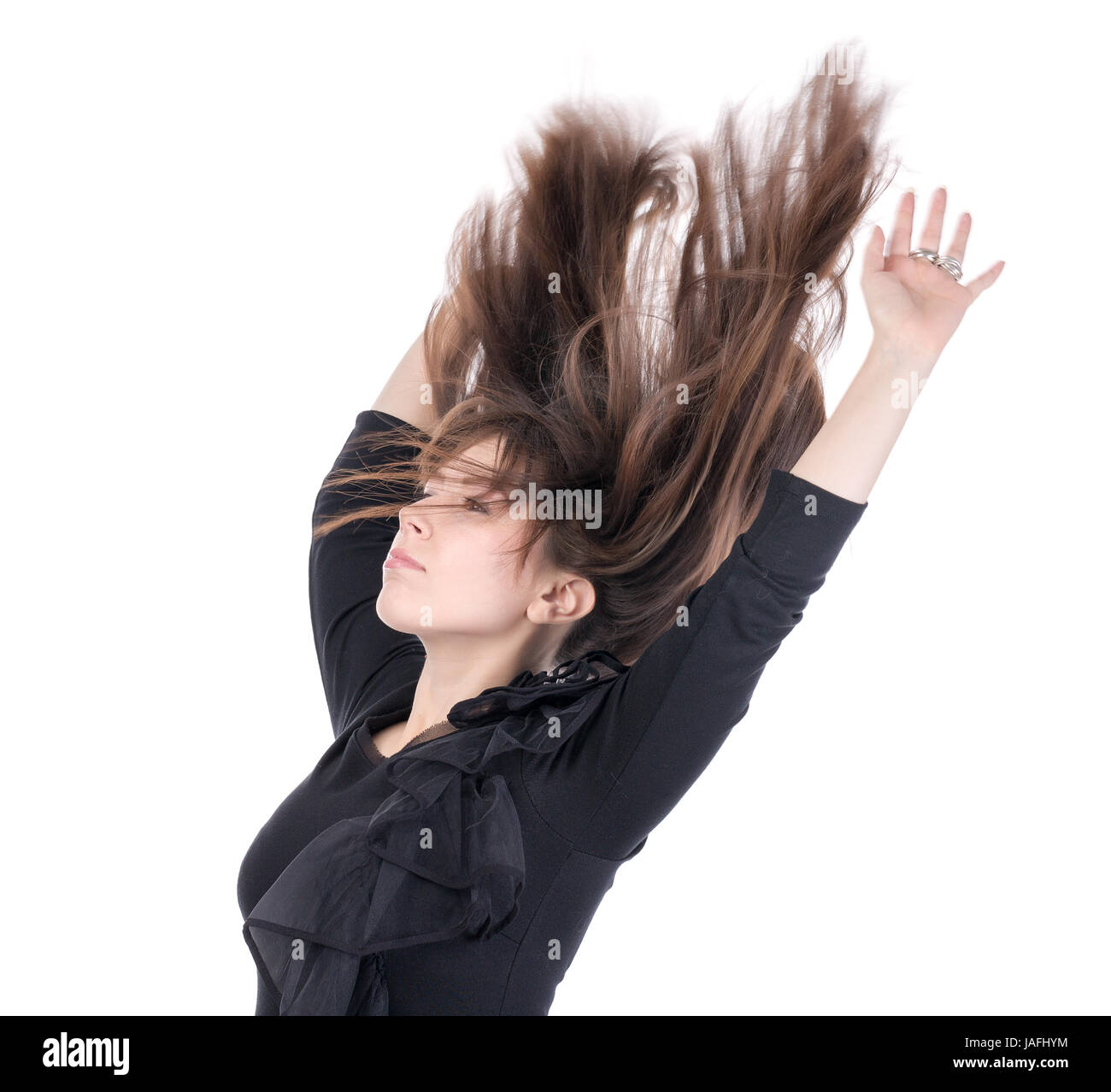 Young woman with her long straight brunette hair flying in the air and ...