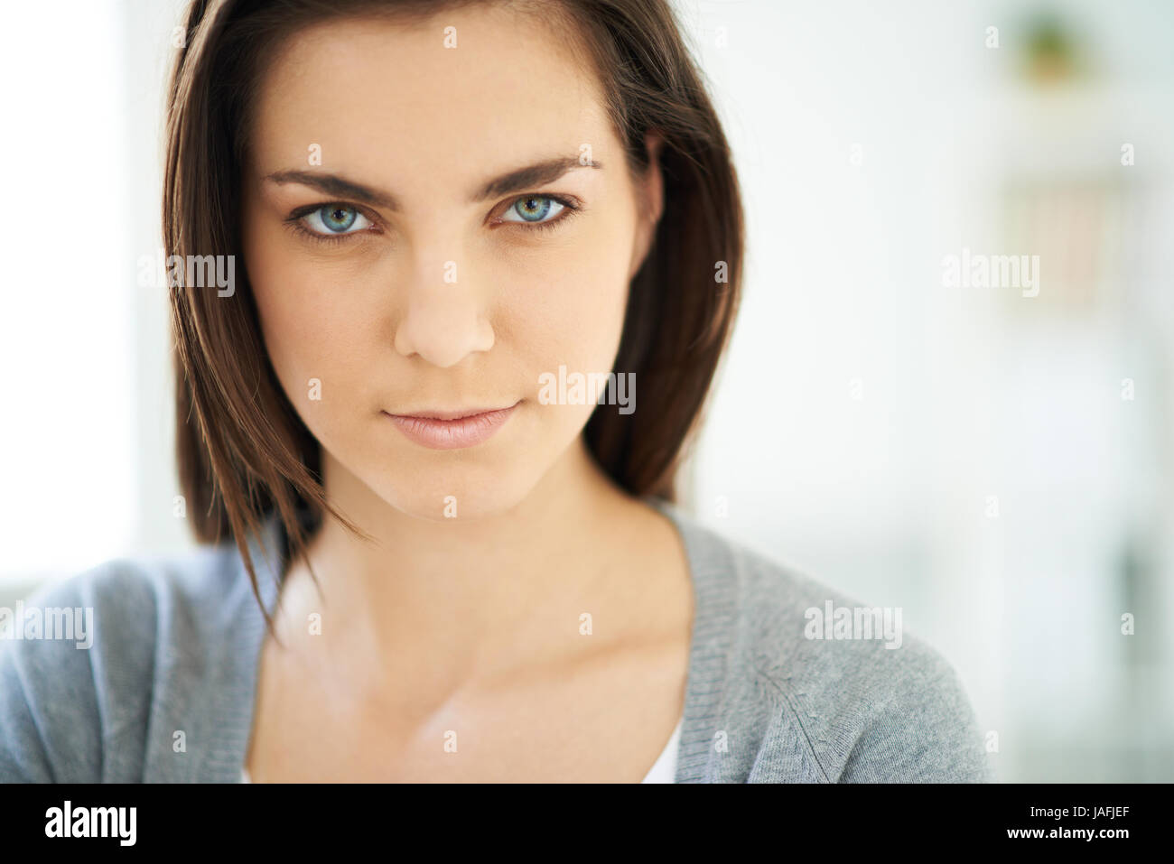 Young woman with serious expression looking at camera Stock Photo - Alamy