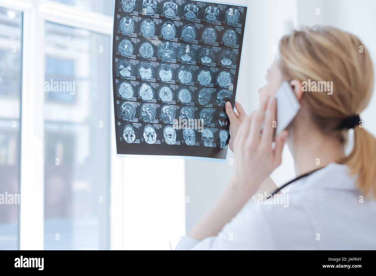 Analyzing brain checkup. Concentrated skilled experienced radiologist ...