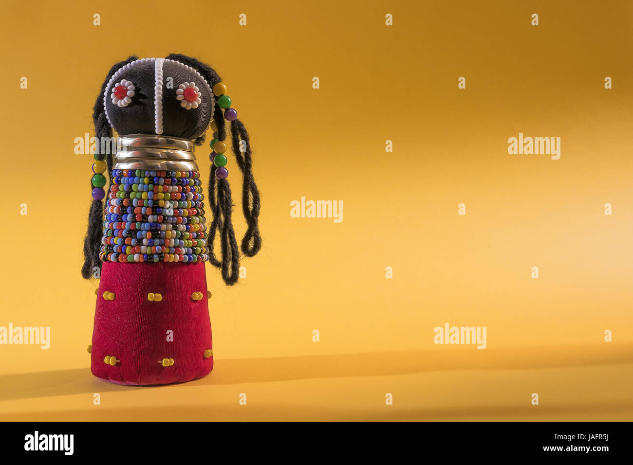 African cloth doll isolated on yellow background Stock Photo - Alamy