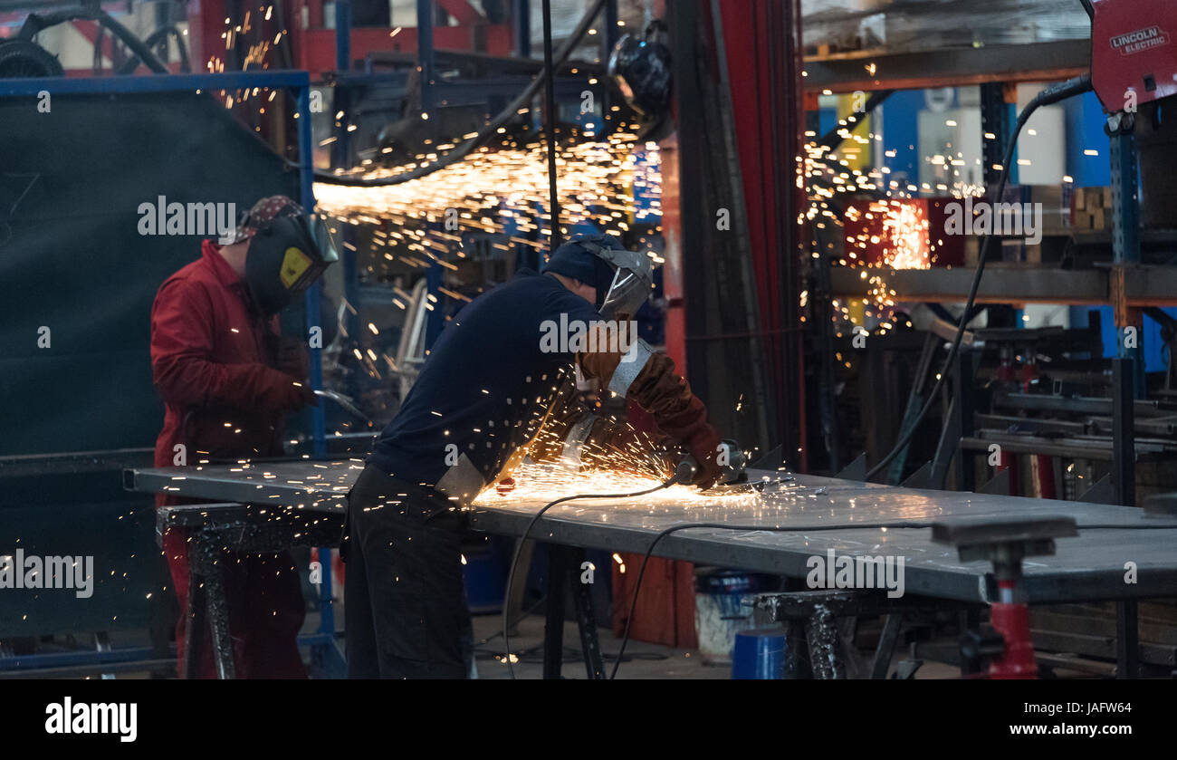 Workers in a factory working with metal on the shop floor Stock Photo ...