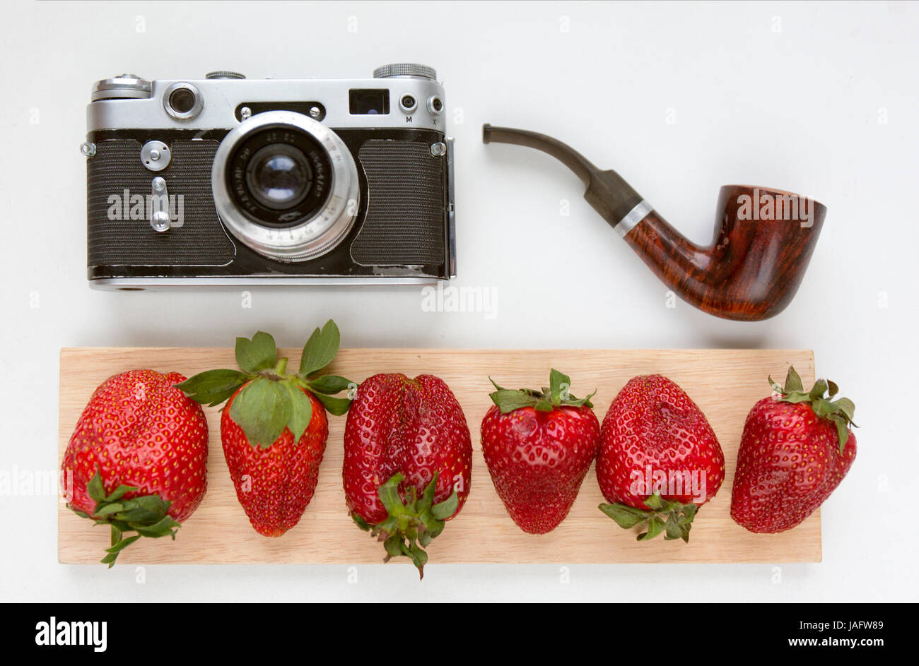 Mock up for artwork with old camera, red strawberries and smoking pipe ...