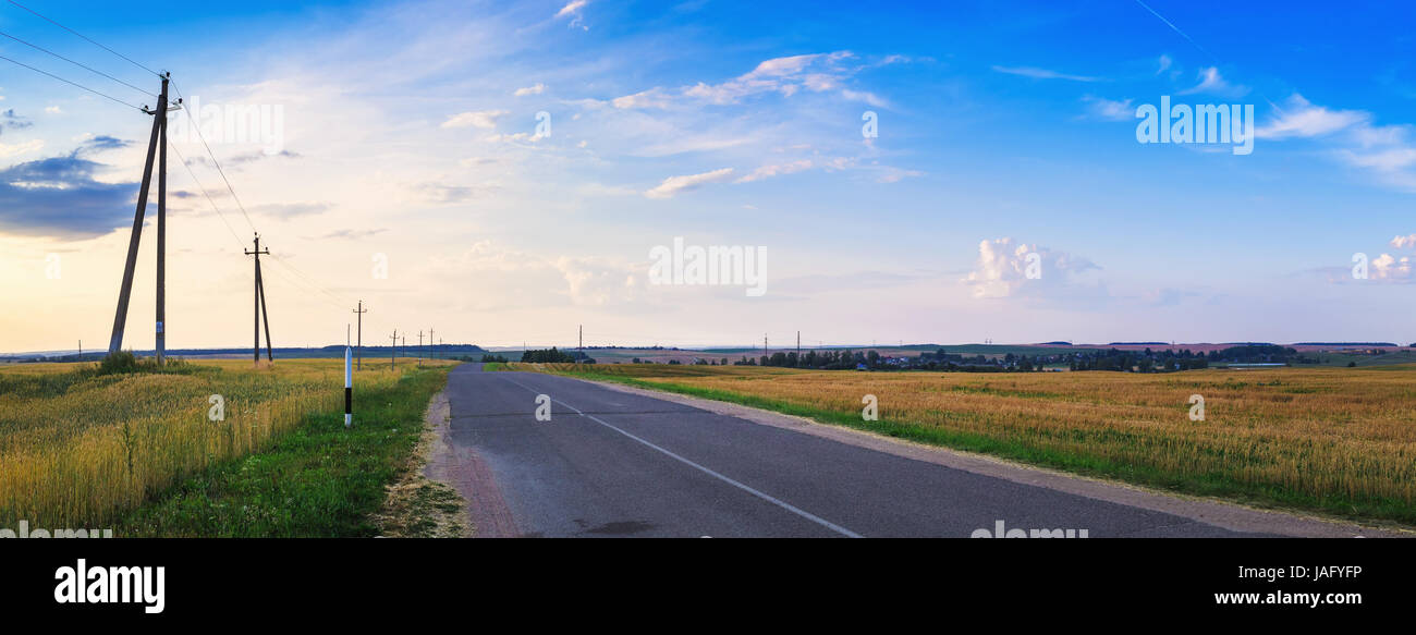 Panoramic rural landscape with an asphalt road and a heavenly sky ...