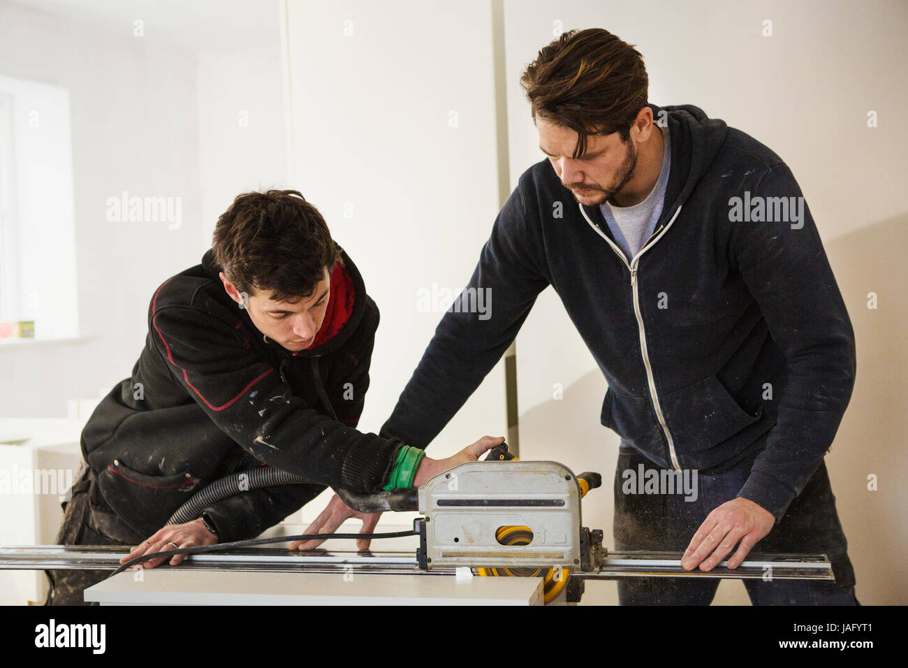 Two builders, cutting plasterboard with a circular saw Stock Photo - Alamy