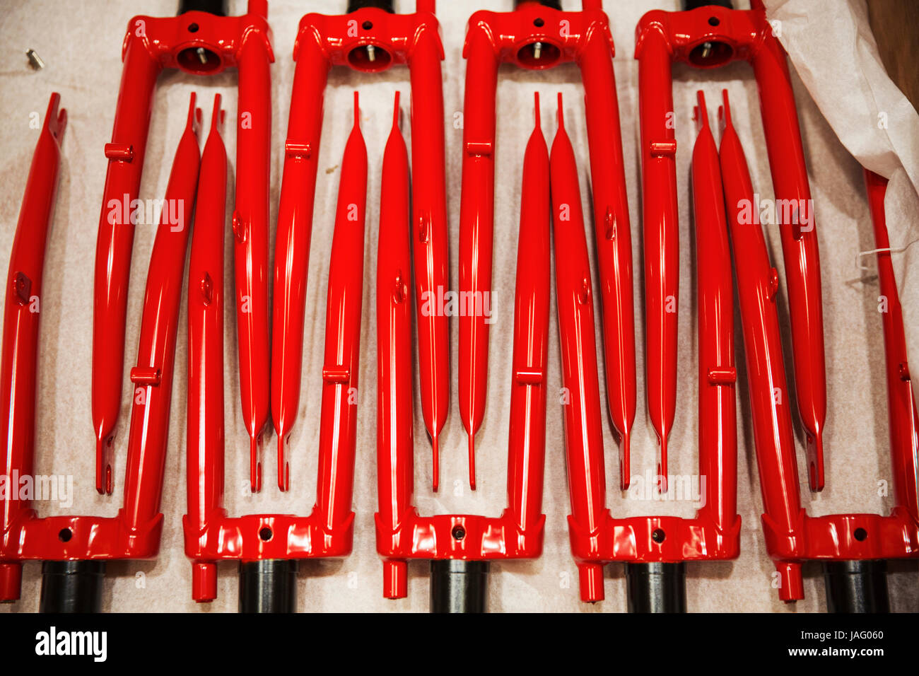 Close up of red metal shapes, red bicycle forks laid out in a pattern ...