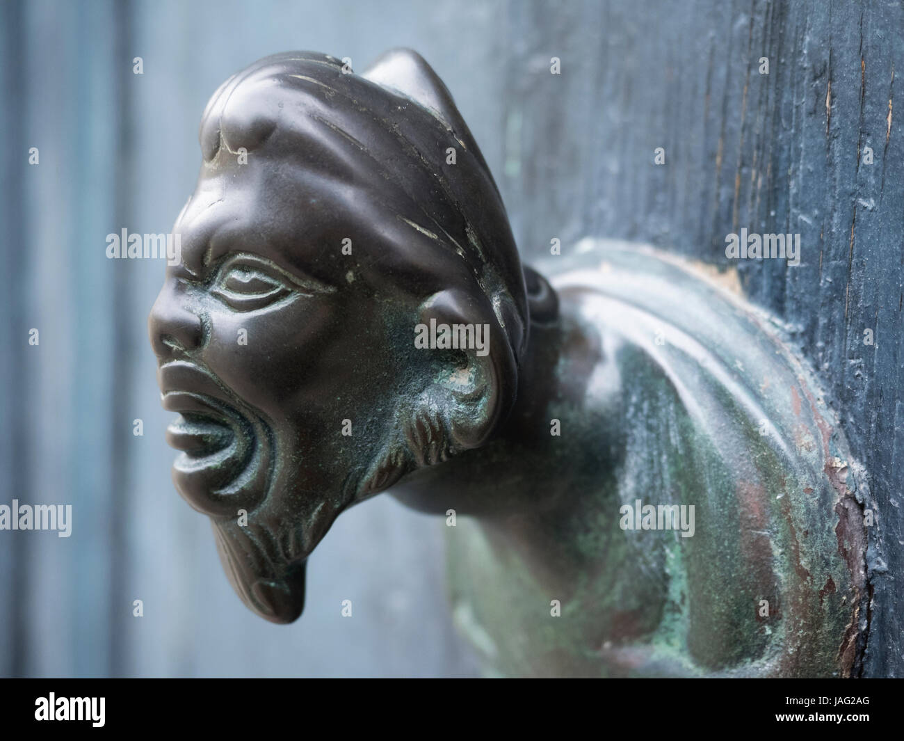 Venice. A metal handle or knocker, a human or goblin head grimacing ...