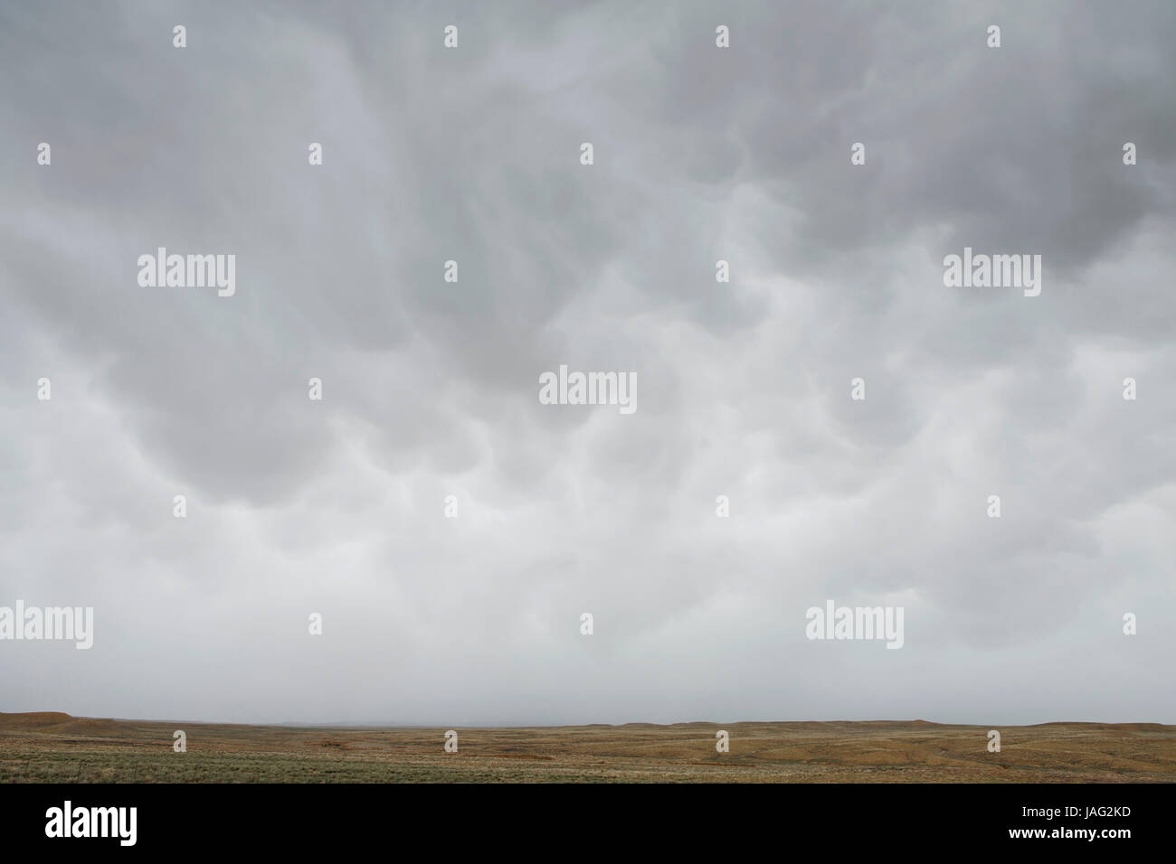 Ominous storm clouds in the sky, white and grey, over an open space ...