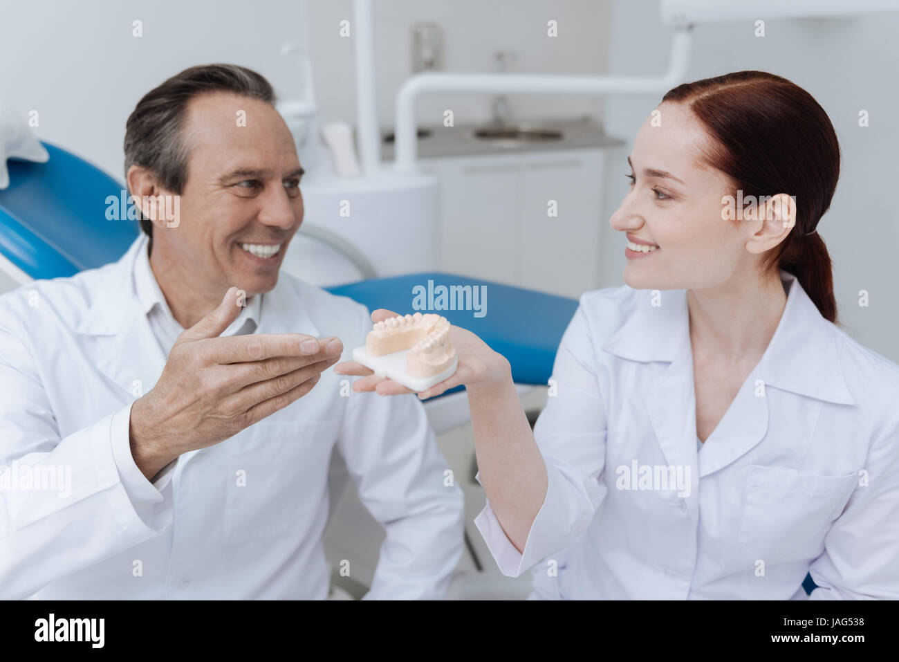 Good teeth. Attractive female intern keeping smile on her face holding ...