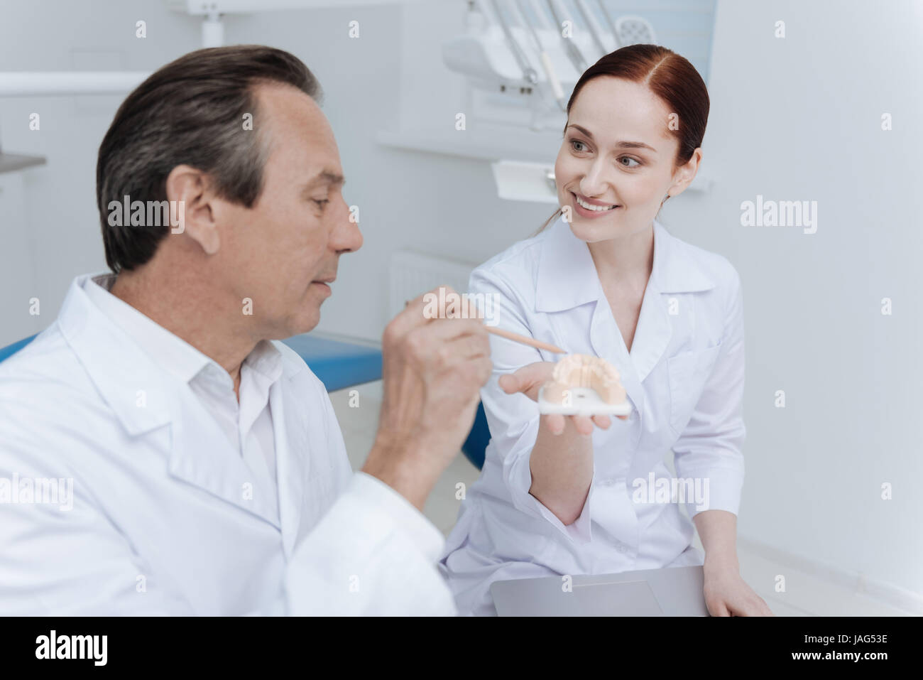 Lower jaw. Serious doctor sitting in semi position keeping pencil in ...