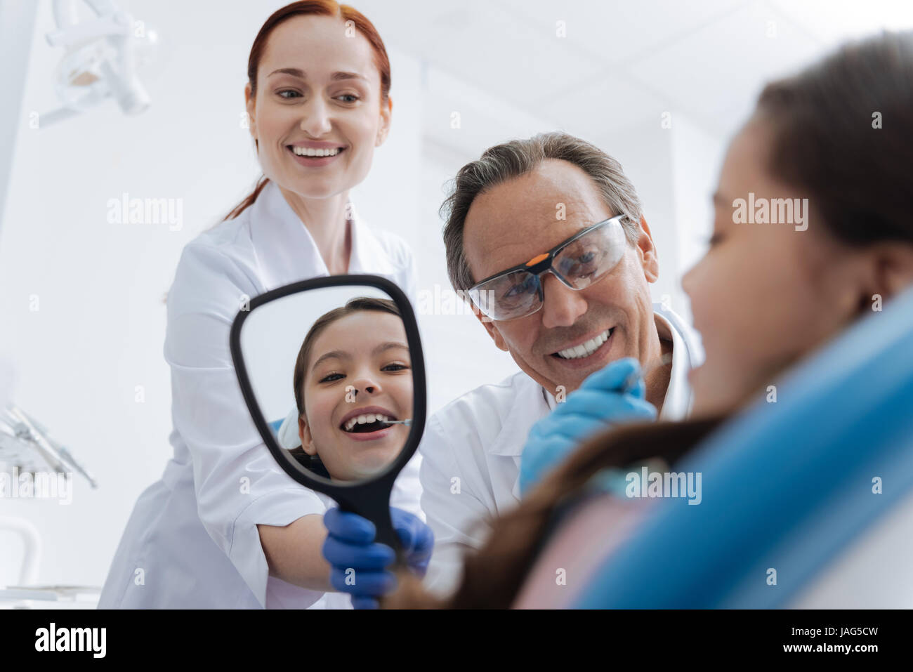 Expressing emotions. Positive delighted dentist showing his white teeth ...