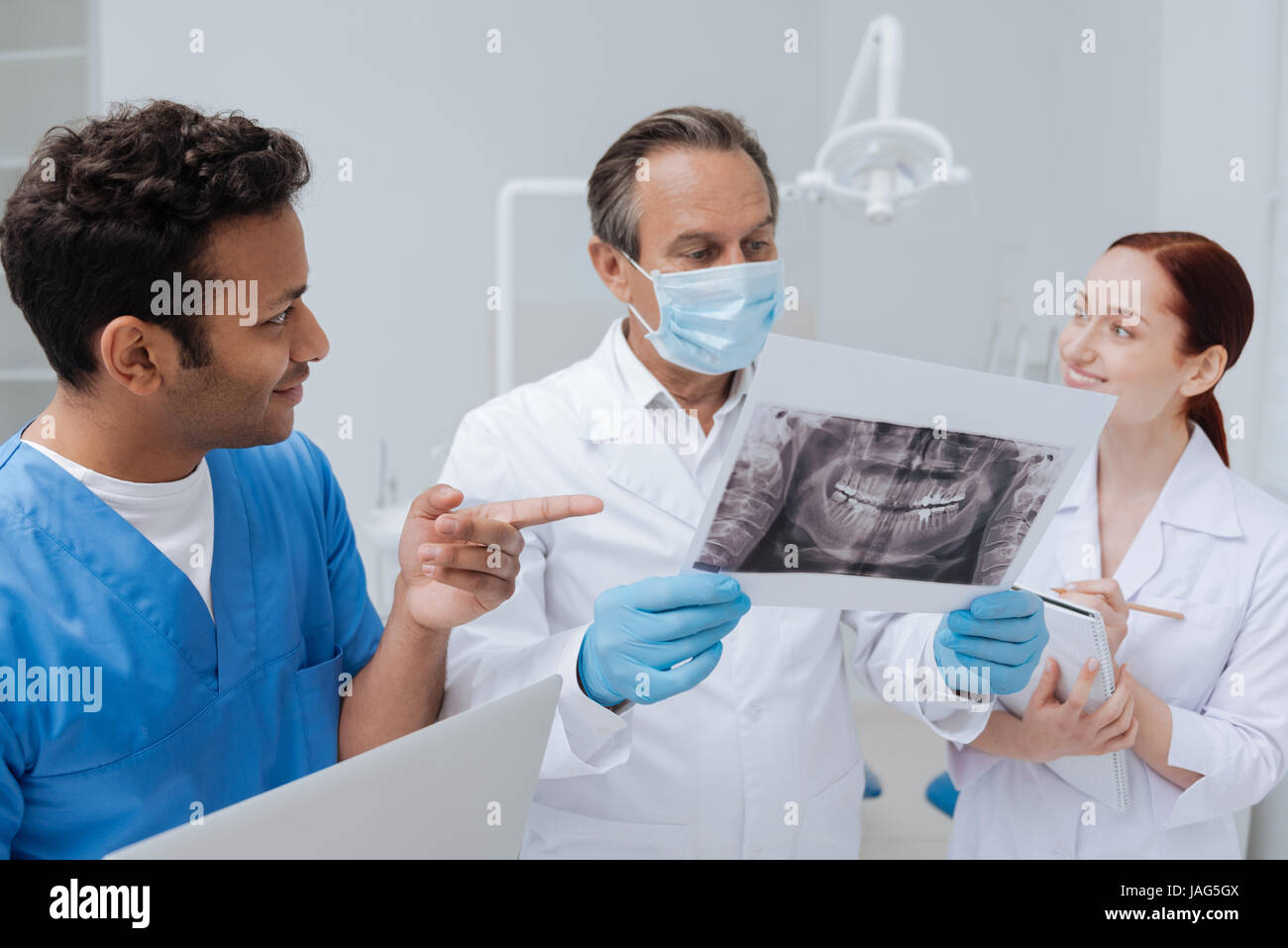 Great results. Smiling intern standing in semi position holding laptop ...