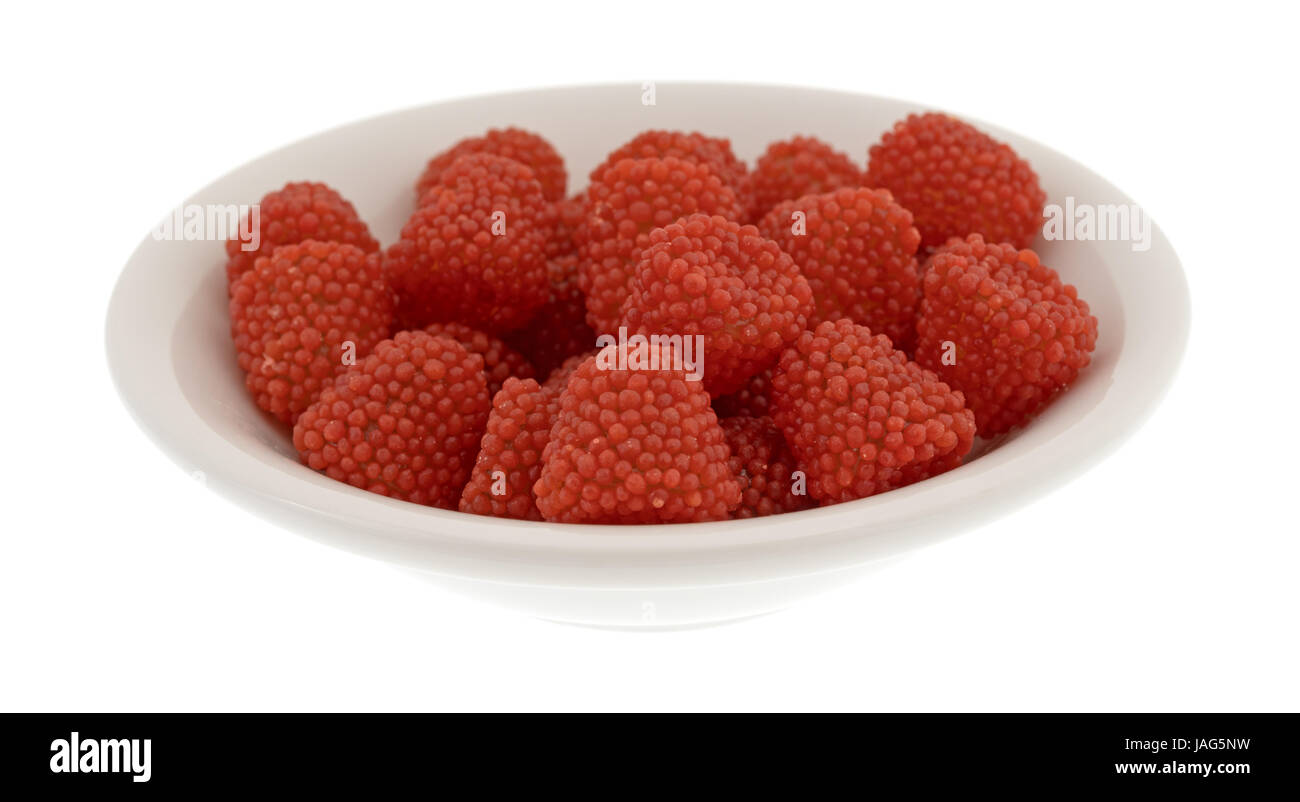 A small bowl filled with raspberry shaped candies isolated on a white ...