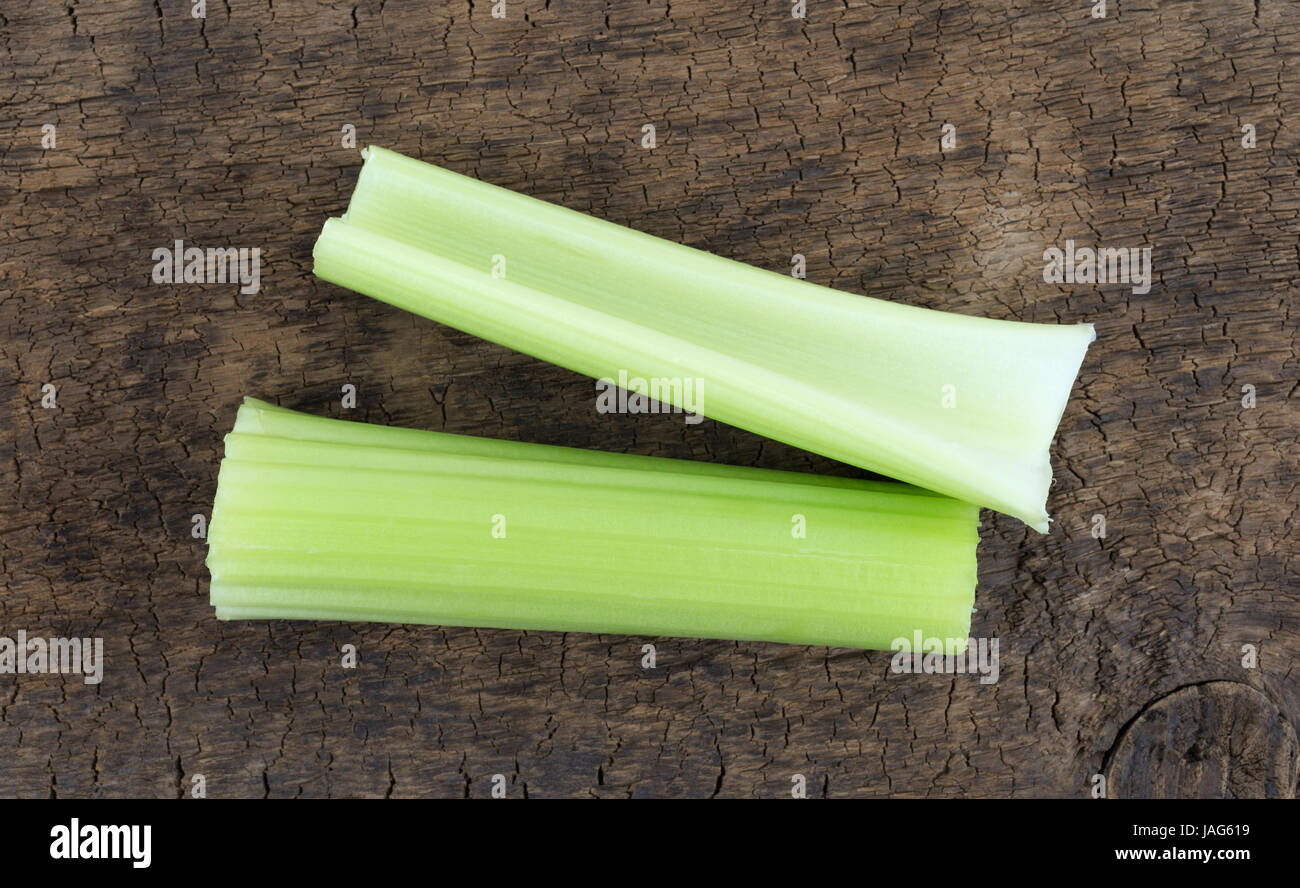 Top view of two celery sticks atop an old worn brown board Stock Photo ...