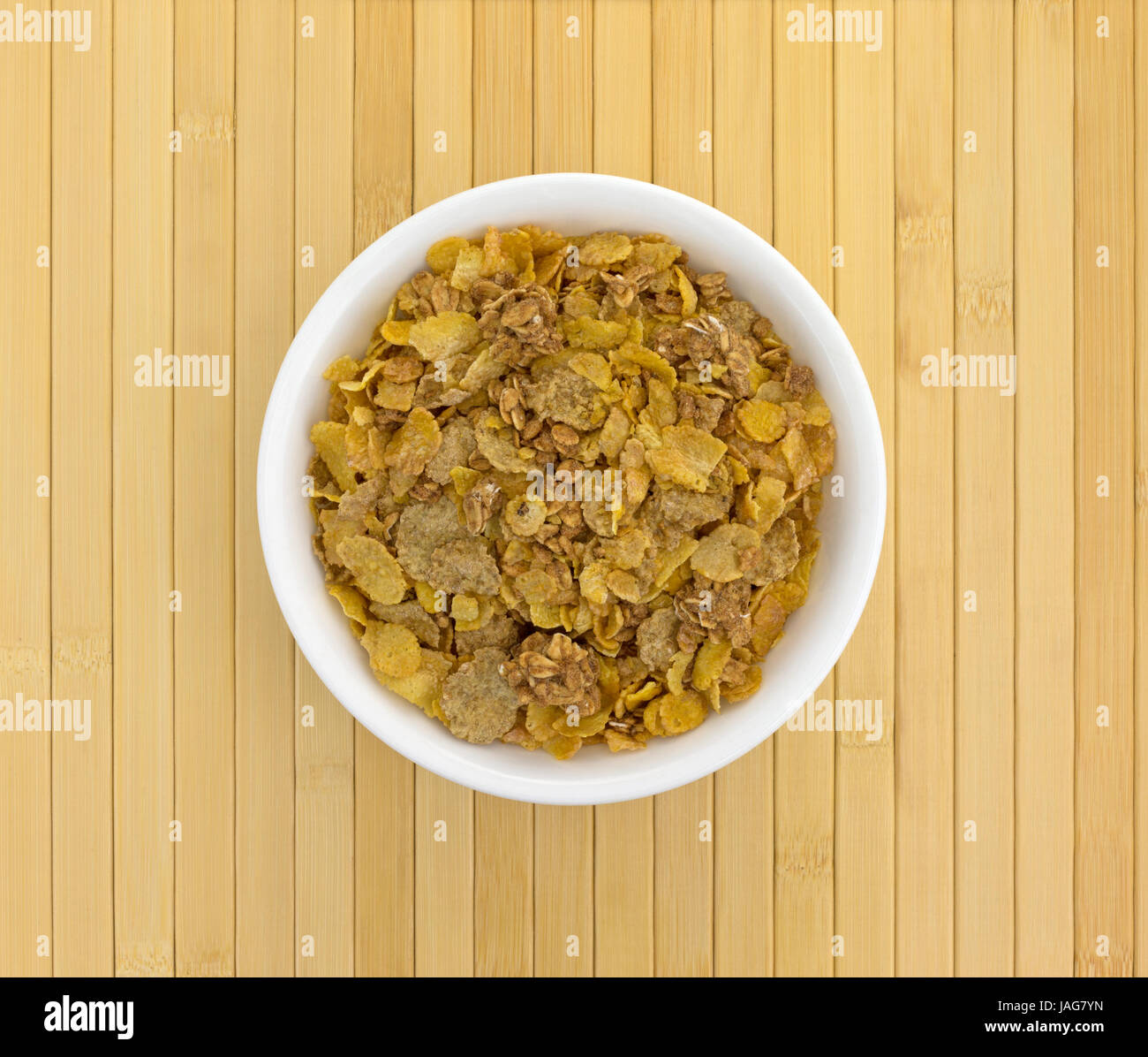 Top view of a white bowl filled with dry multigrain breakfast cereal on ...