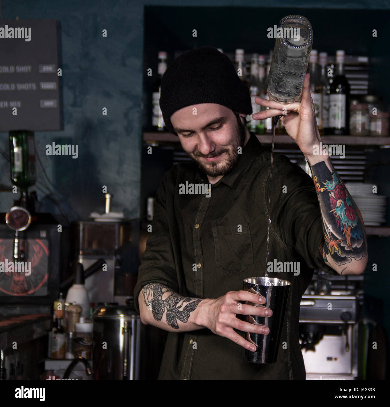 Flair smiling bartender in action in a bar Stock Photo - Alamy