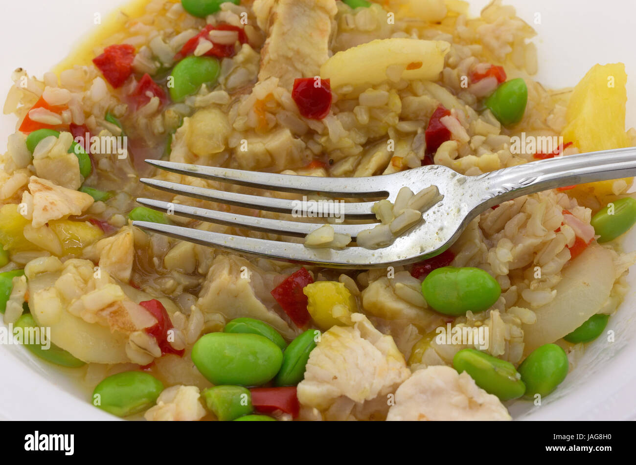 Close view of a bowl filled with a meal of chicken, rice, water ...