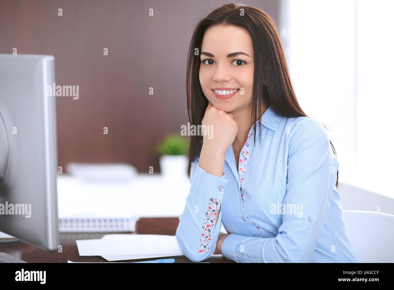 Young business woman sitting a at the table in office Stock Photo - Alamy
