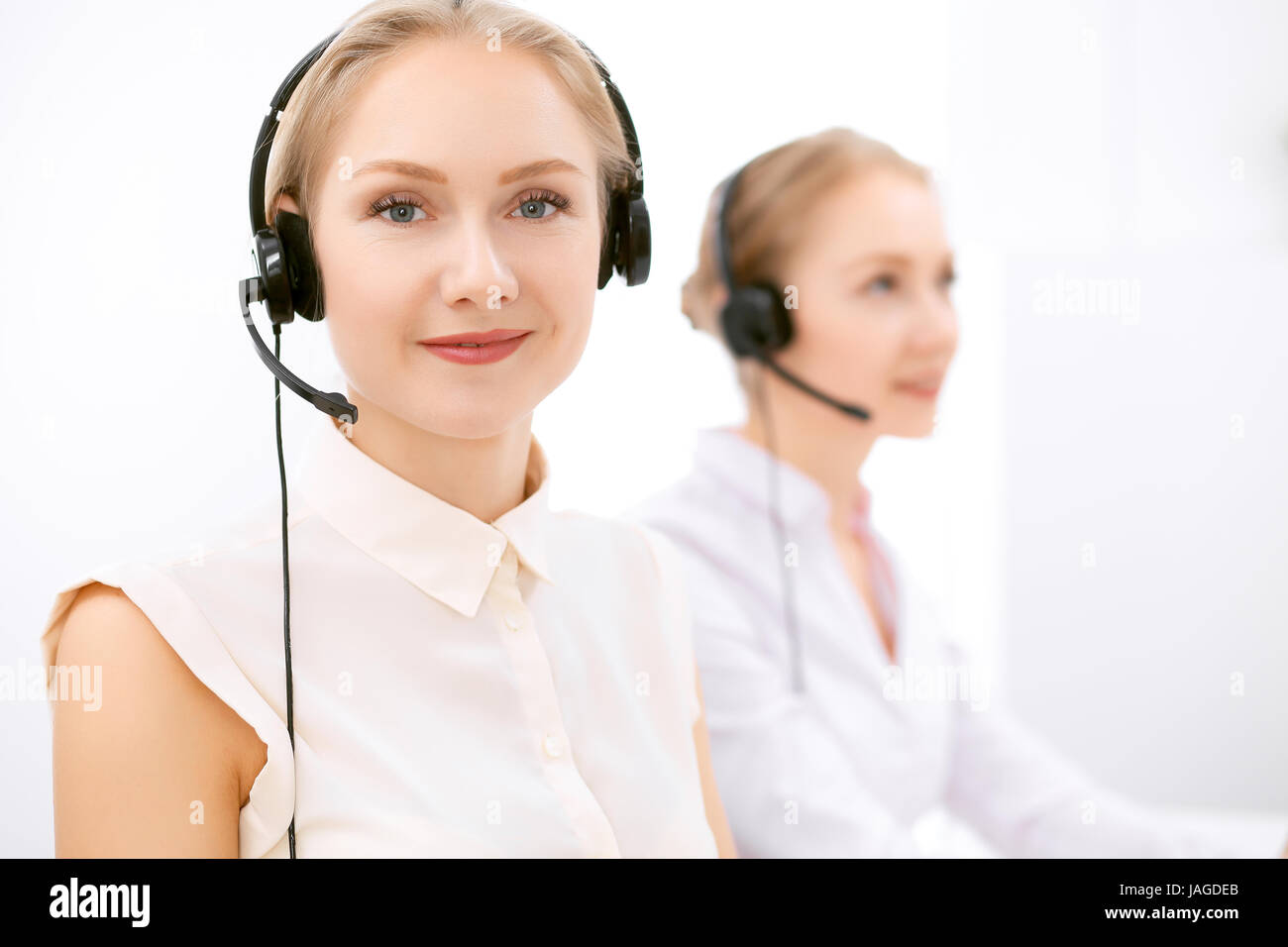 Call center. Focus on beautiful blonde woman in headset Stock Photo - Alamy