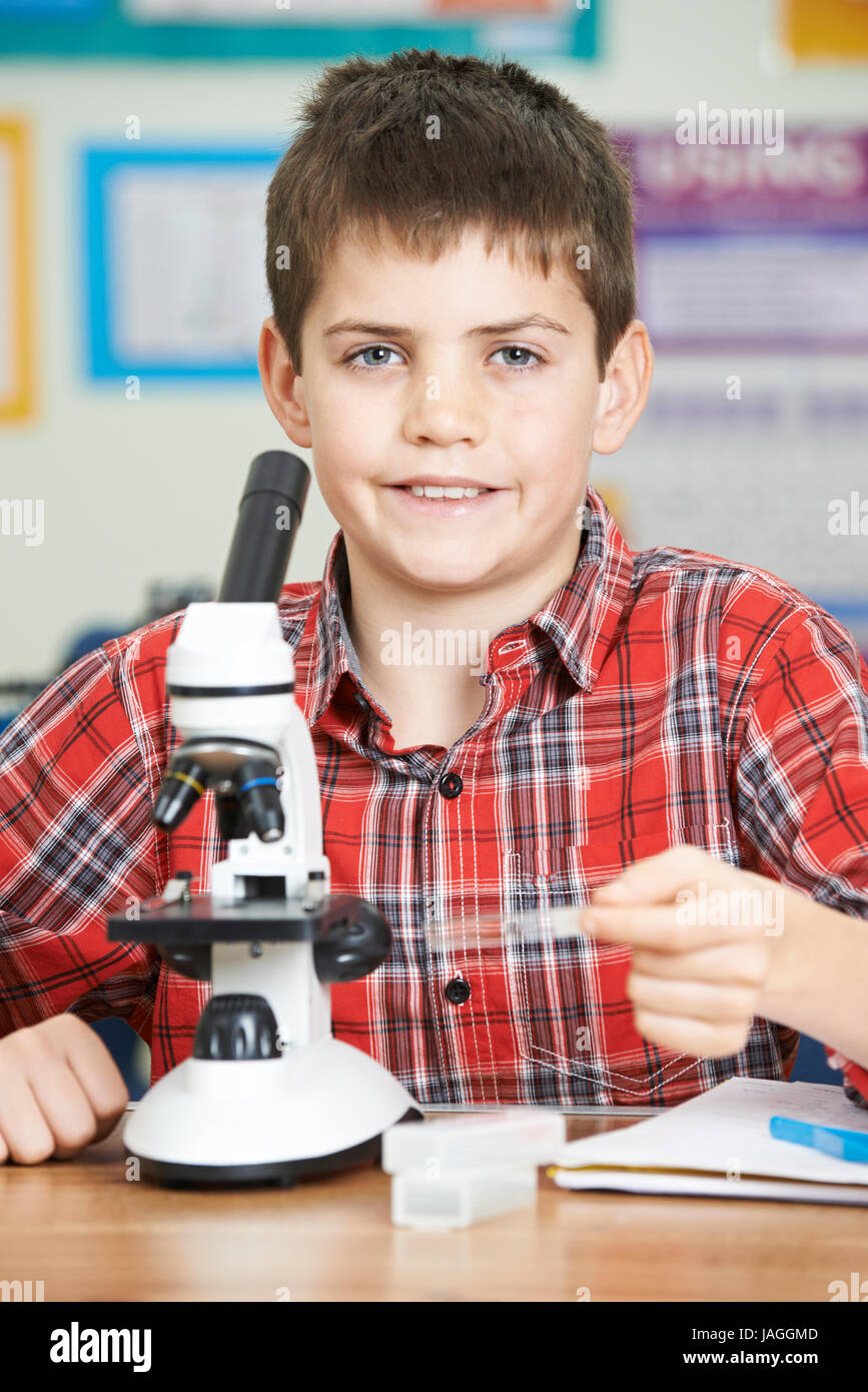 Male Pupil Using Microscope In Science Lesson Stock Photo - Alamy