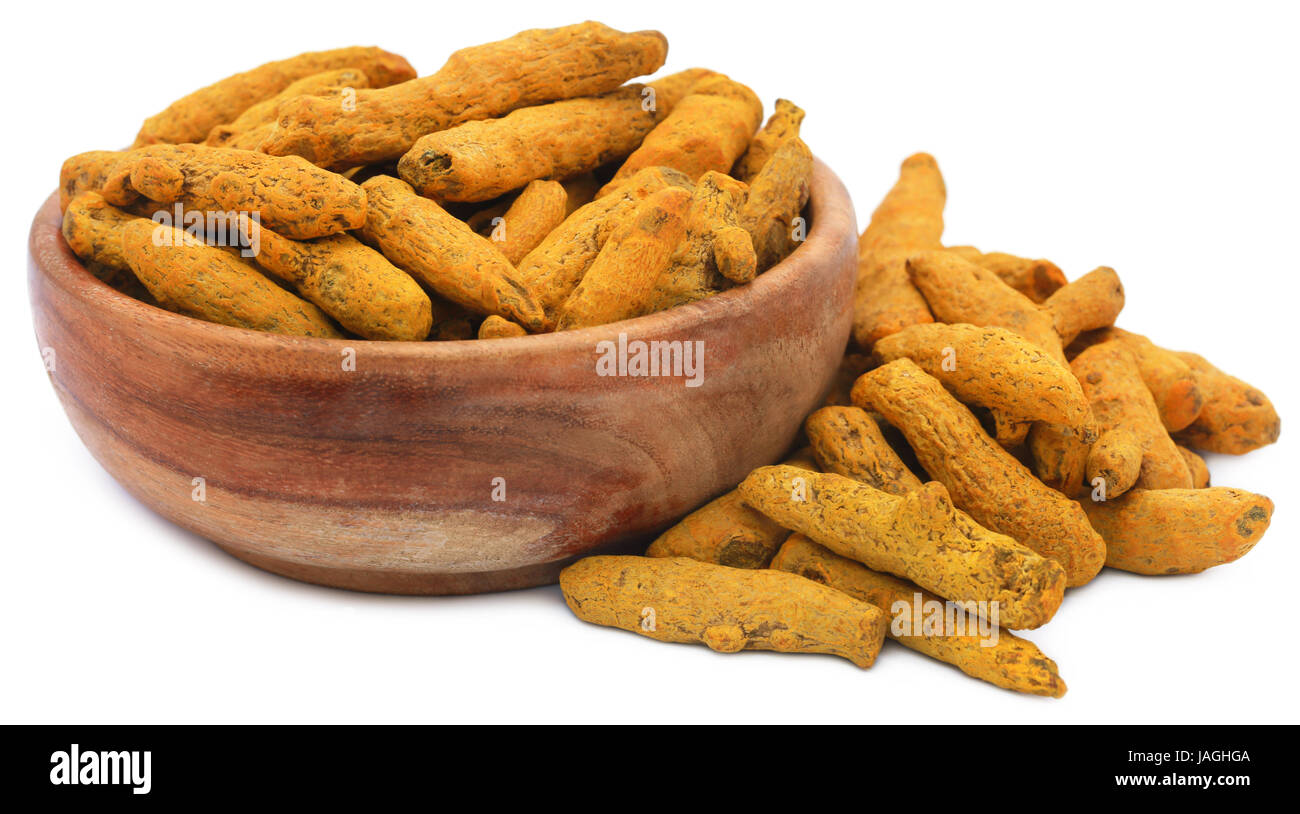 Whole turmeric in a bowl over white background Stock Photo - Alamy