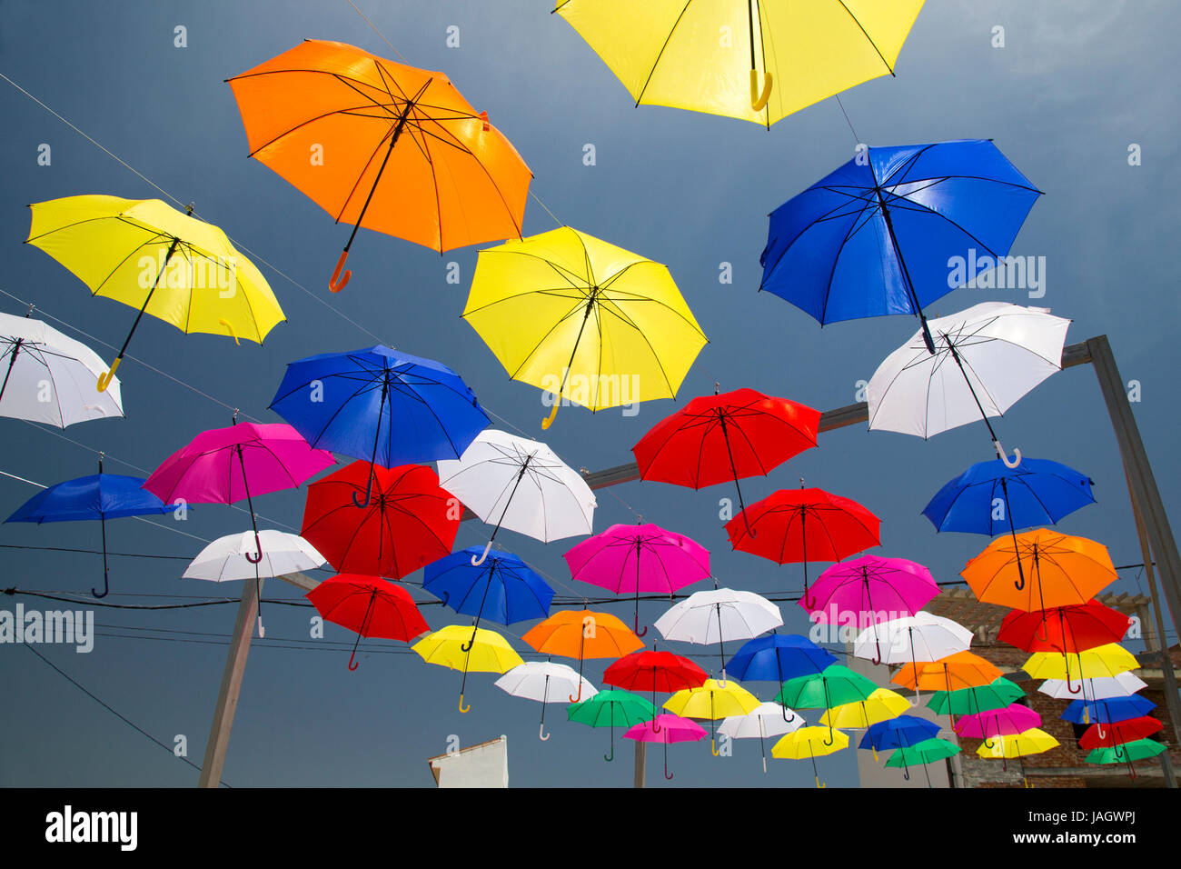 A display of brightly coloured umbrellas hanging above a street in ...