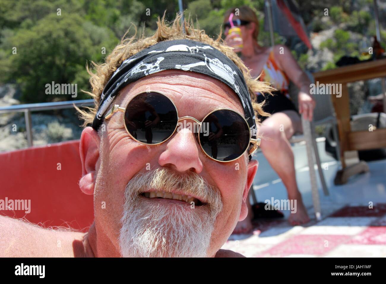 An englishman with a beard wearing a bandana and cool sunglasses while ...