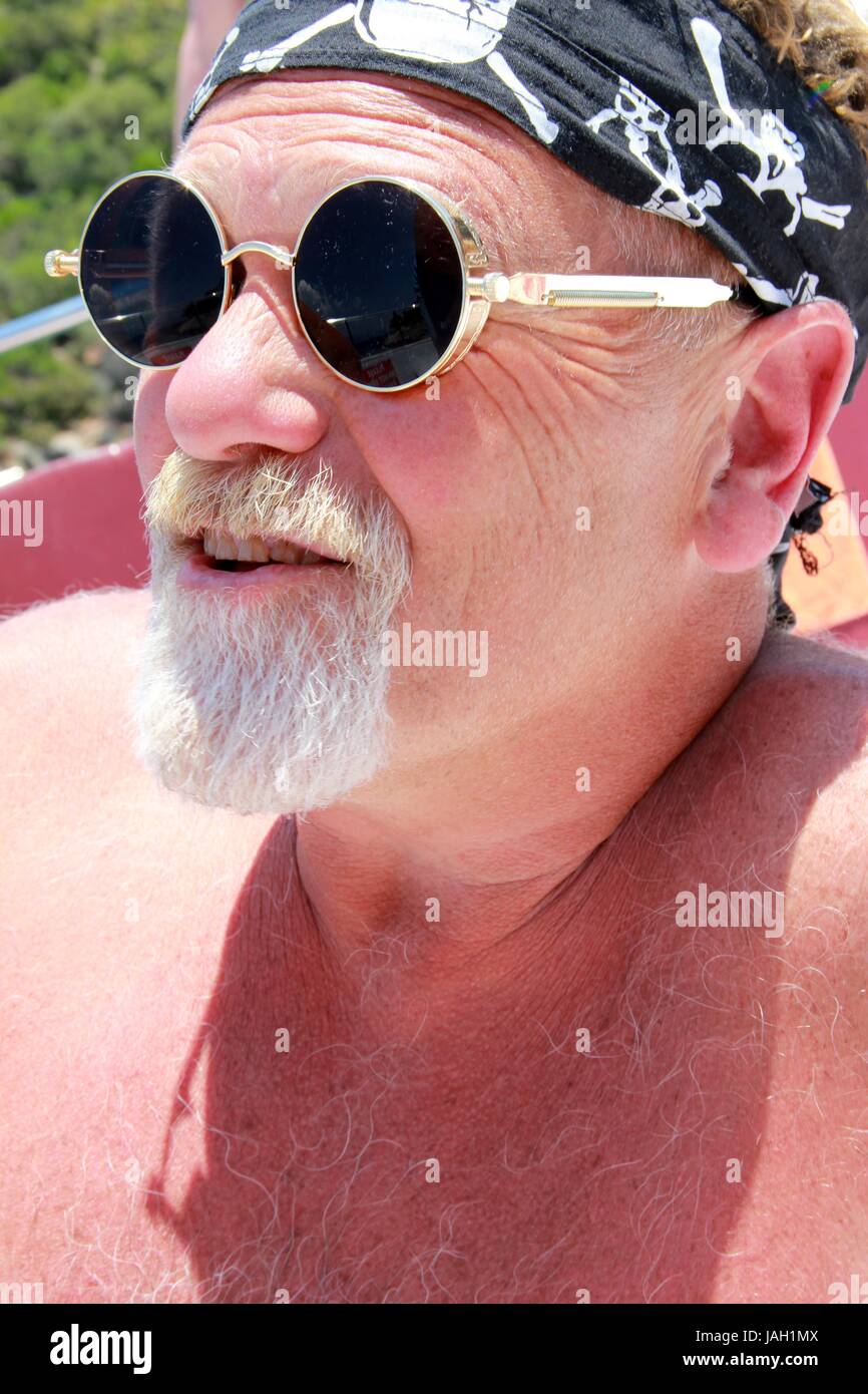 An englishman with a beard wearing a bandana and cool sunglasses while ...