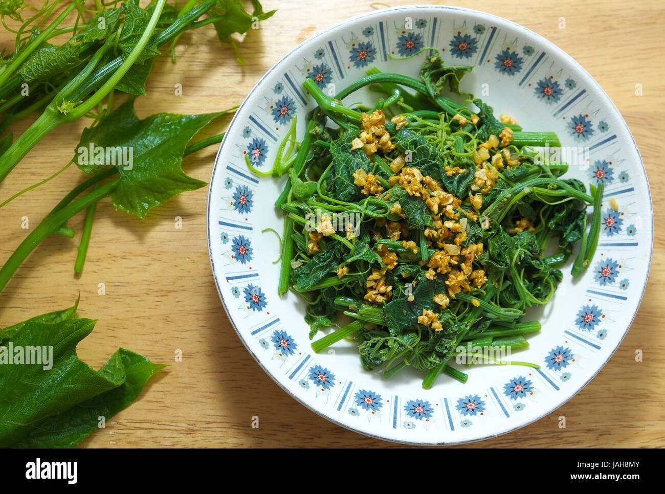 Stir fried green Chayote with fried garlic, on wooden table Stock Photo ...