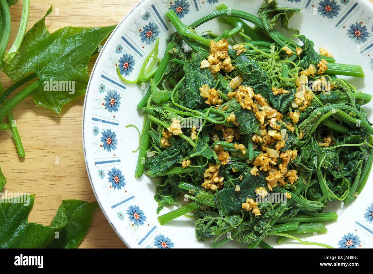 Stir fried green Chayote with fried garlic, on wooden table Stock Photo ...