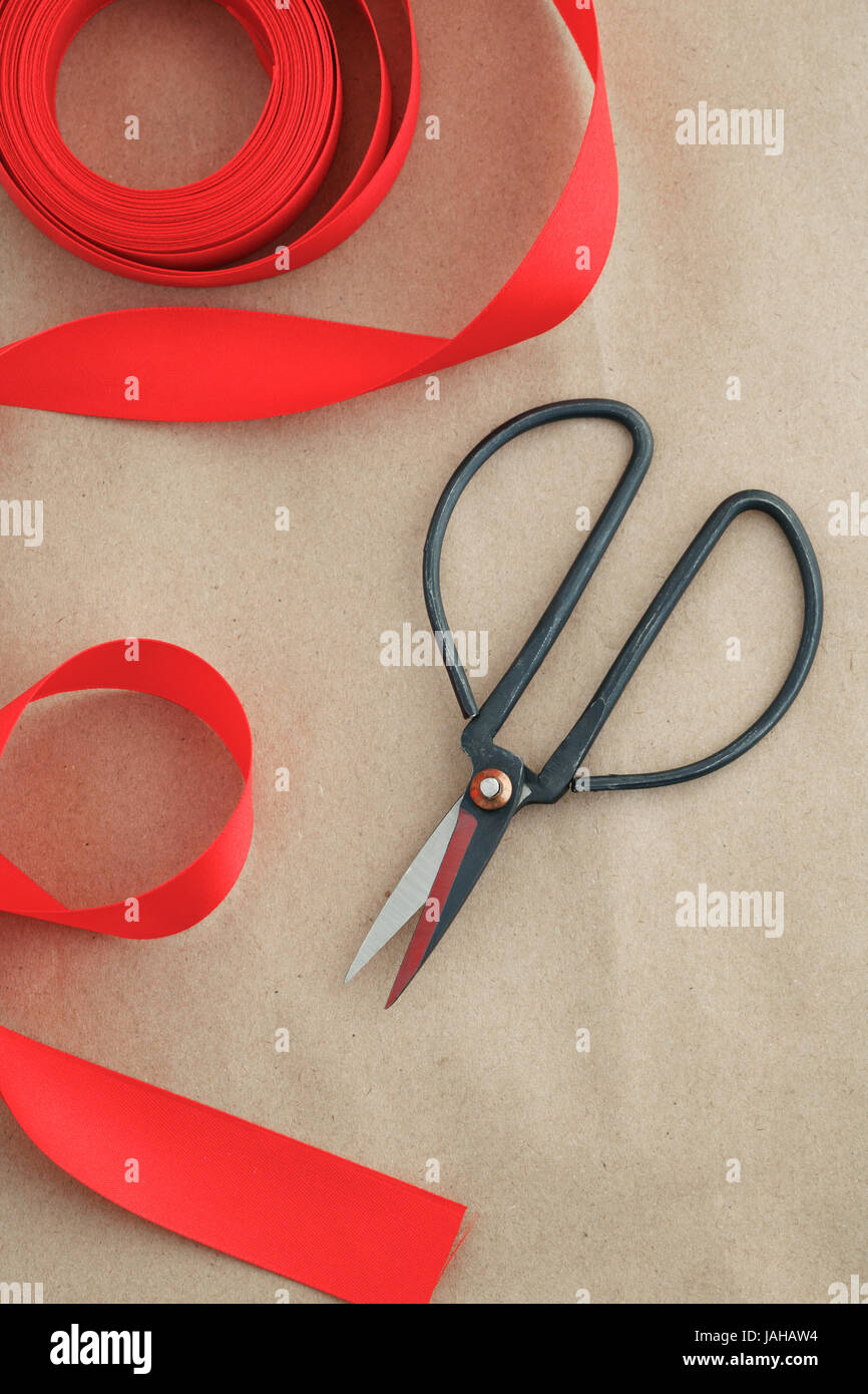 Preparing for the packaging of gifts. Black vintage scissors and red ...