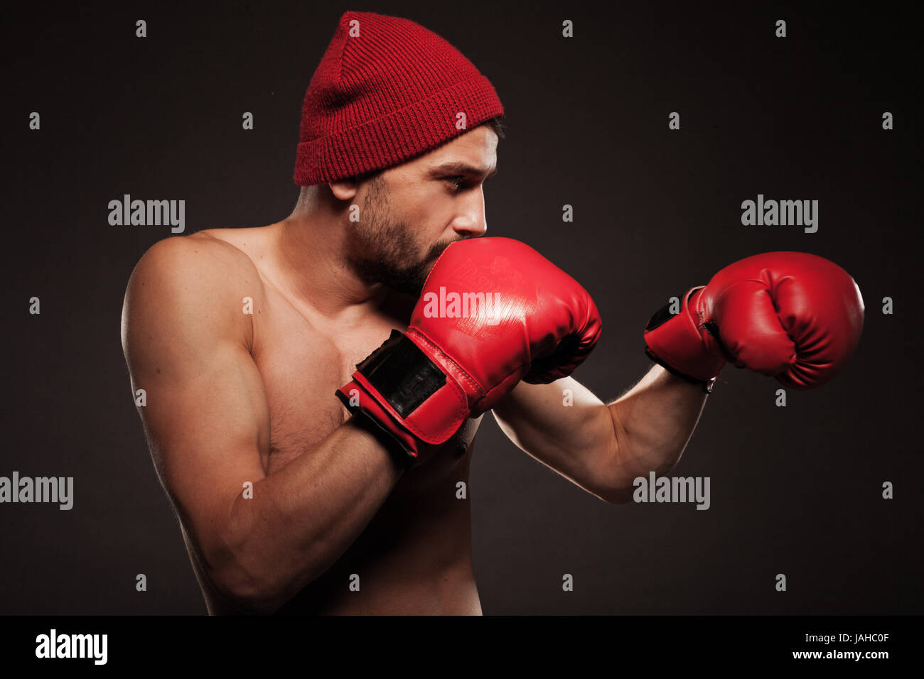 Profile of a young and fit caucasian boxer in a fighting pose wearing ...