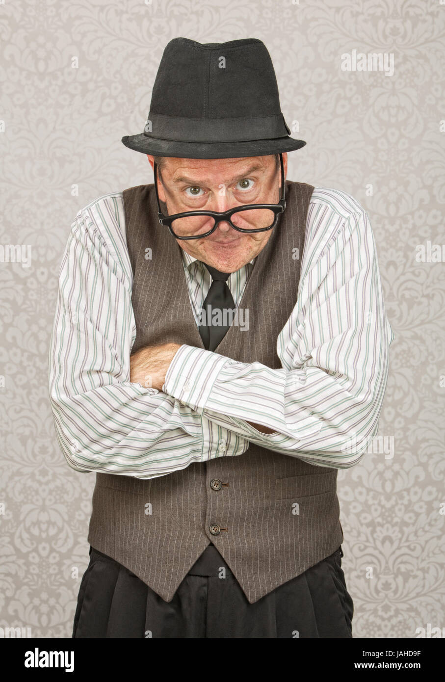 Single mad businessman with hat and folded arms Stock Photo - Alamy