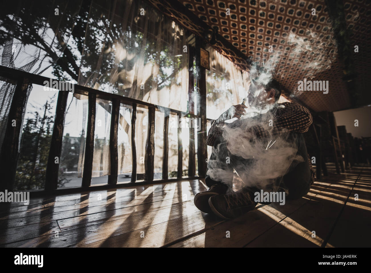 vaping young man produces vapor on sunset silhouette Stock Photo - Alamy