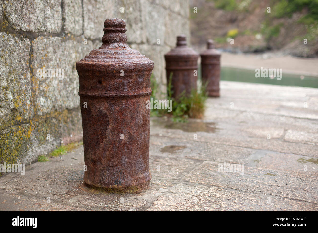 Mooring bollards on the harbour wall at Polkerris, Cornwall Stock Photo ...