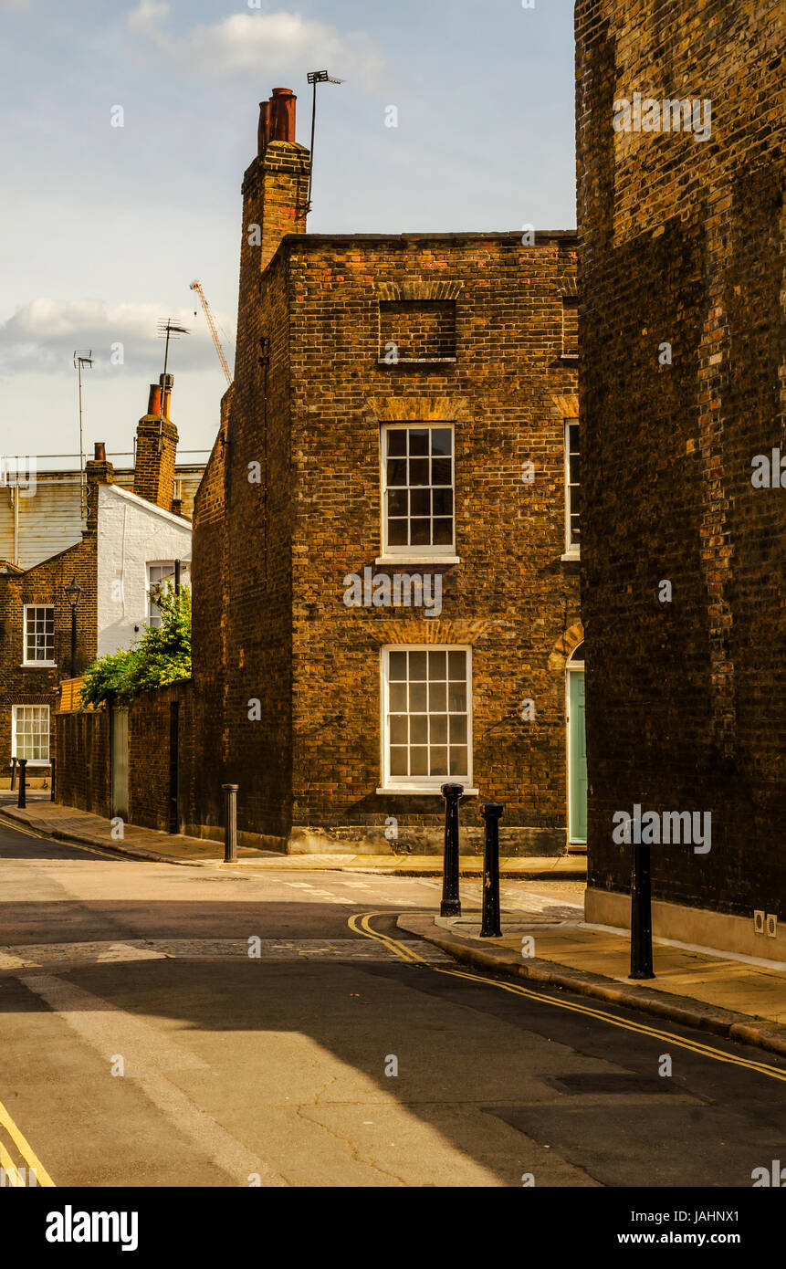 Typical old English buildings, low brick buildings across a narrow ...