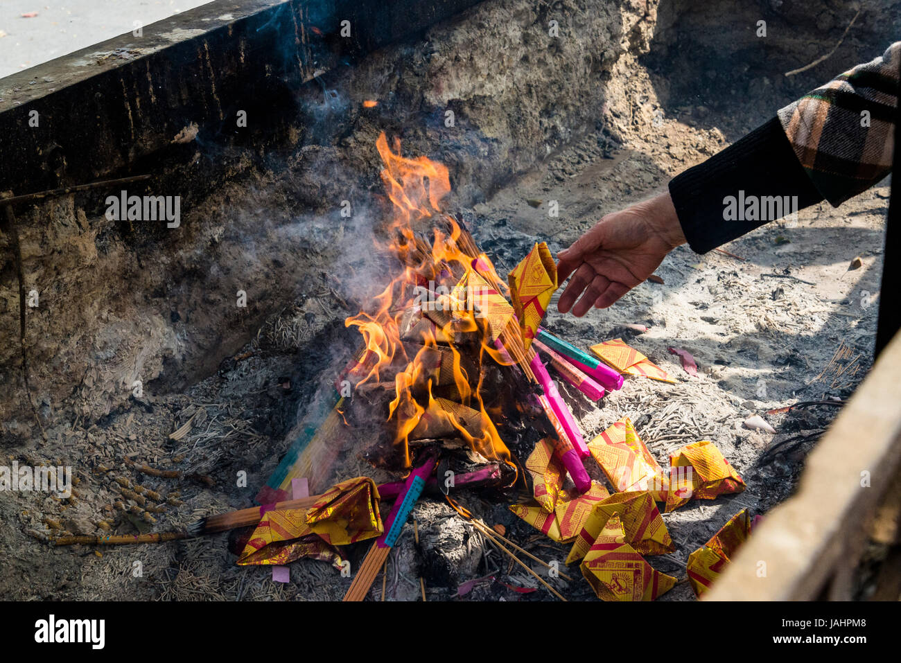 Taoist religious ritual of burning insence and pieces of papers on ...