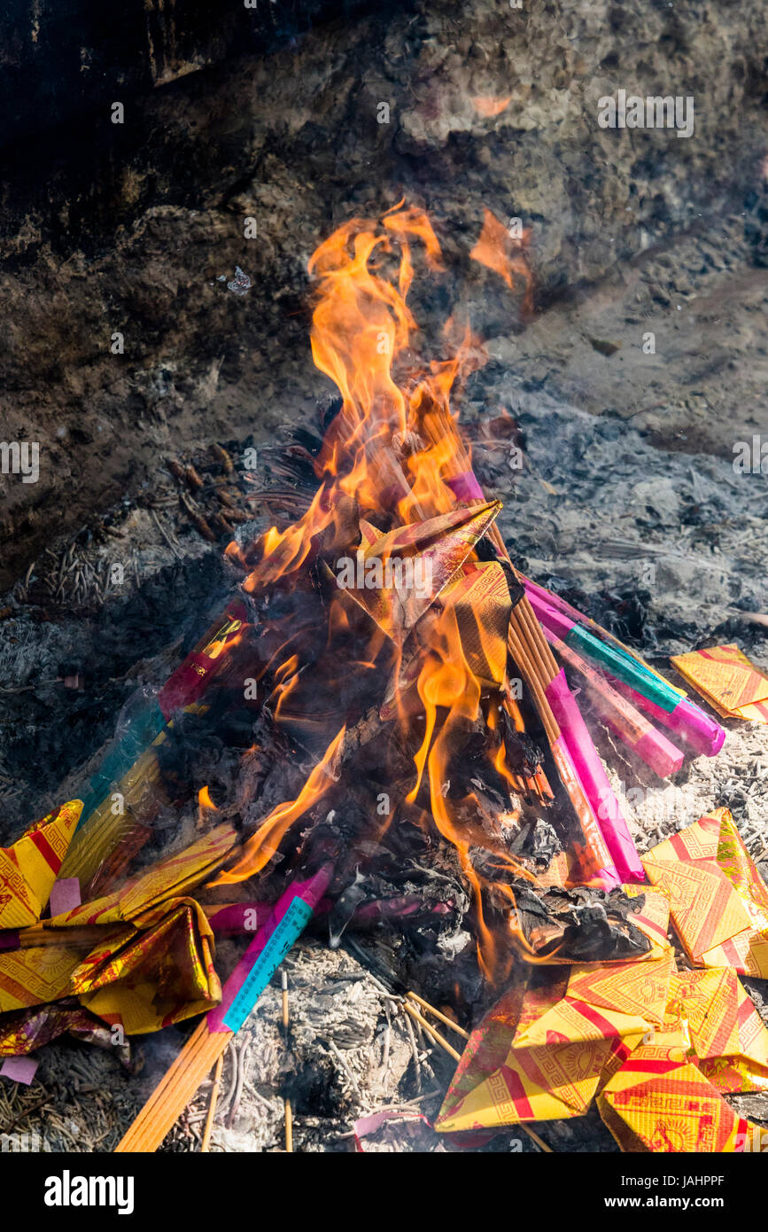 Taoist religious ritual of burning insence and pieces of papers on ...