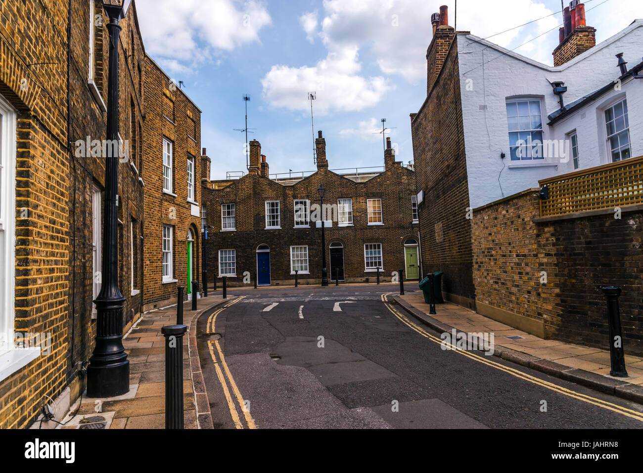 Typical old English buildings, low brick buildings across a narrow ...