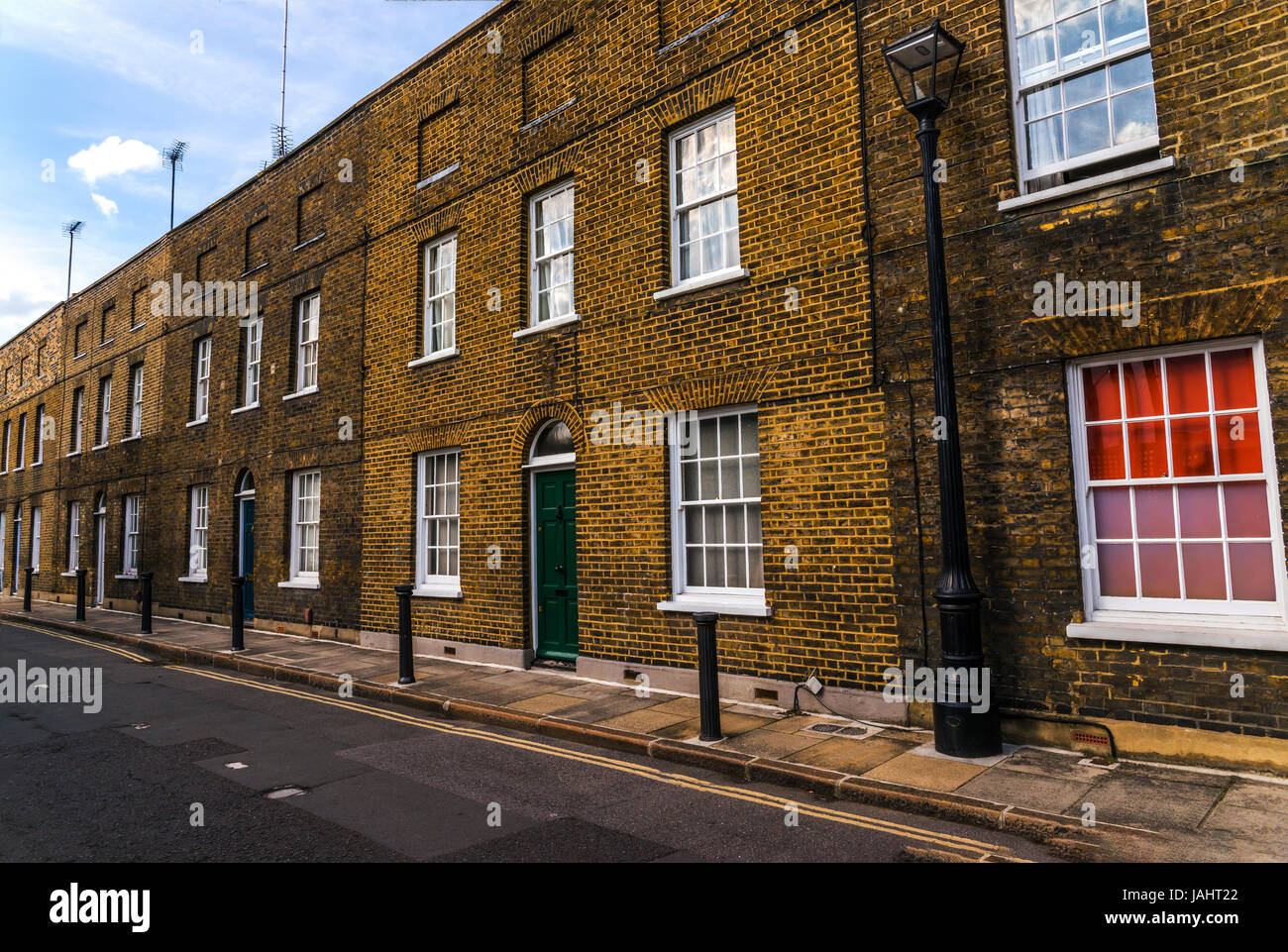 Typical old English buildings, low brick buildings across a narrow ...